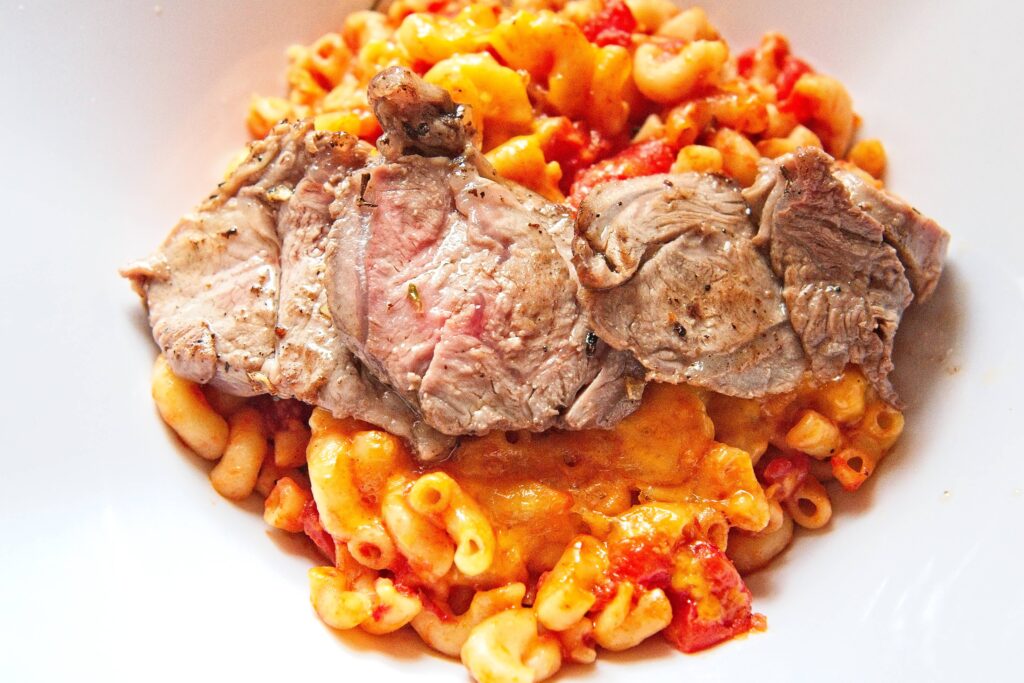 Gigot d’agneau avec un macaroni aux tomates à l’ail et cheddar ...